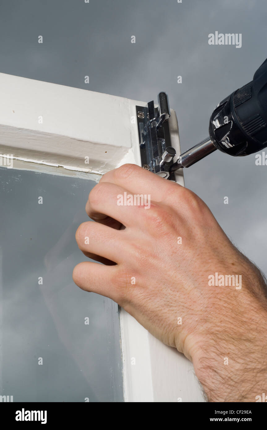 closeup of man drilling lock into window frame Stock Photo - Alamy