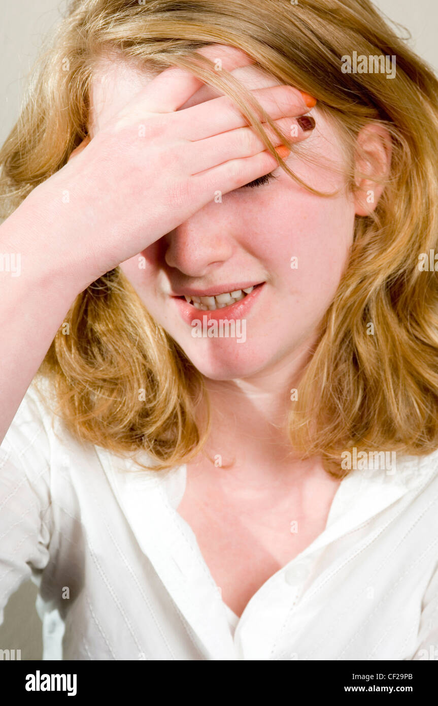 Female with her hand on her forehead Stock Photo - Alamy