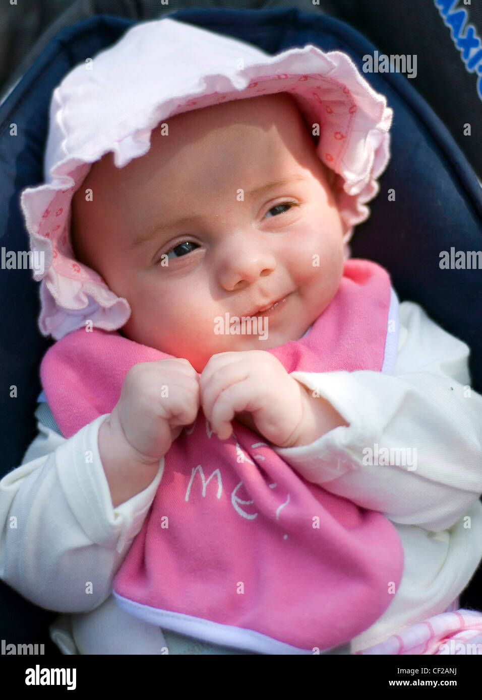 Female three month old baby dressed in a pink hat, white baby grow and ...