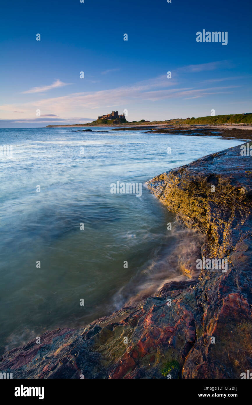 Bamburgh Castle, beach and dunes viewed shortly after sunrise from ...
