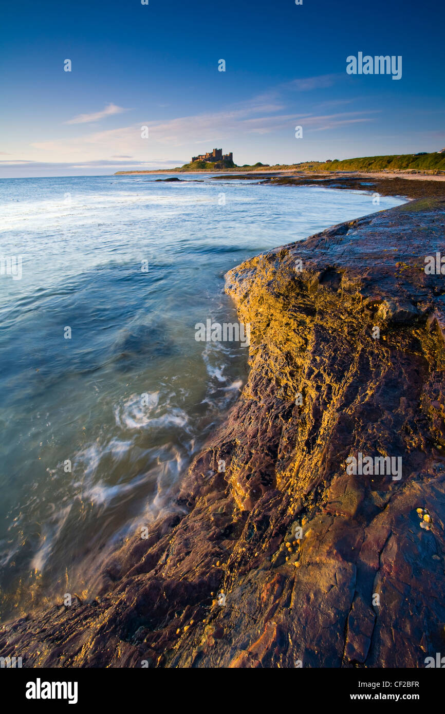 Bamburgh Castle, beach and dunes viewed shortly after sunrise from ...