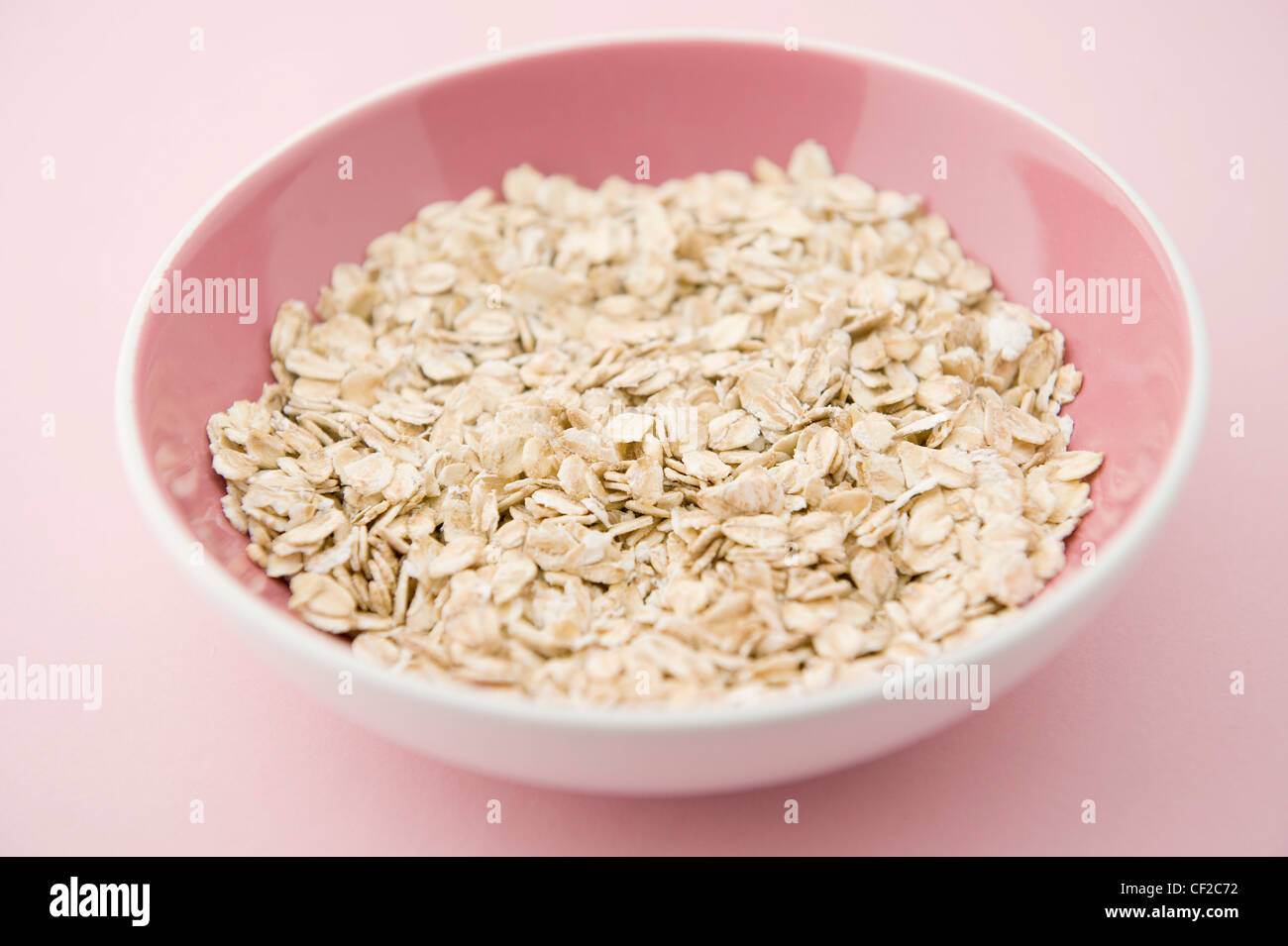 A pink bowl of dry porridge oats Stock Photo - Alamy