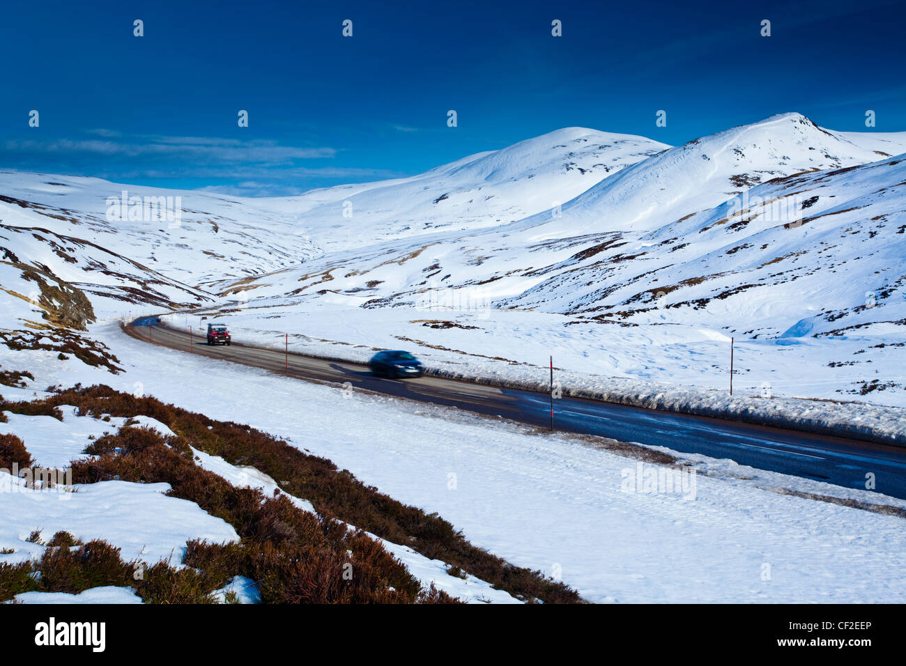 Car and 4 wheel drive travelling along an icy A93 road near the ...
