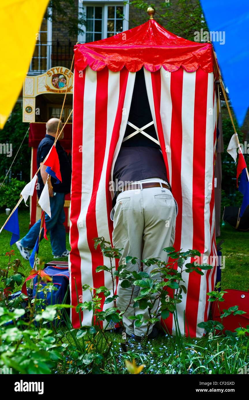 A puppeteer preparing his booth for a Punch and Judy performance at the ...