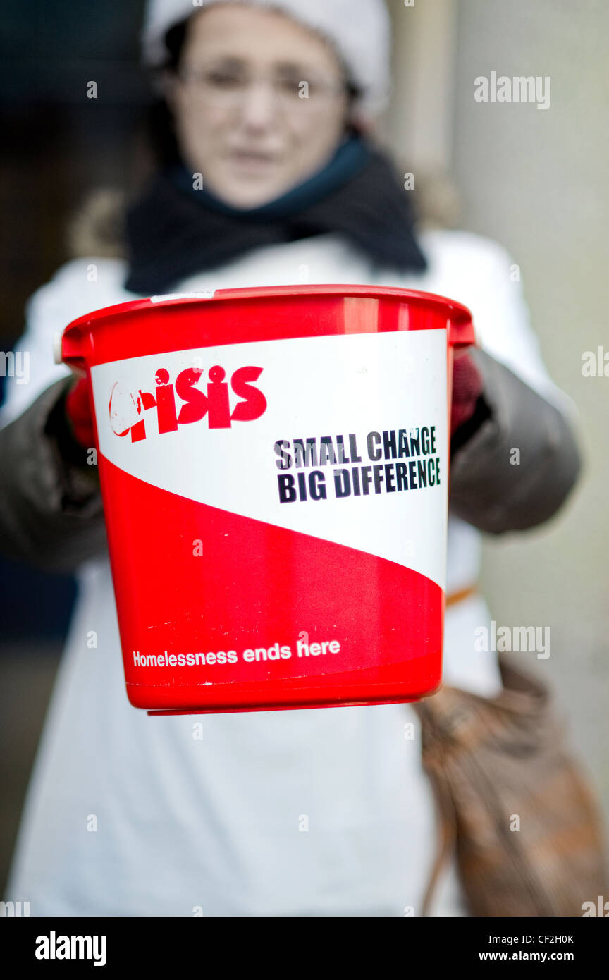 A woman collecting change in a bucket for Crisis at Christmas, the ...