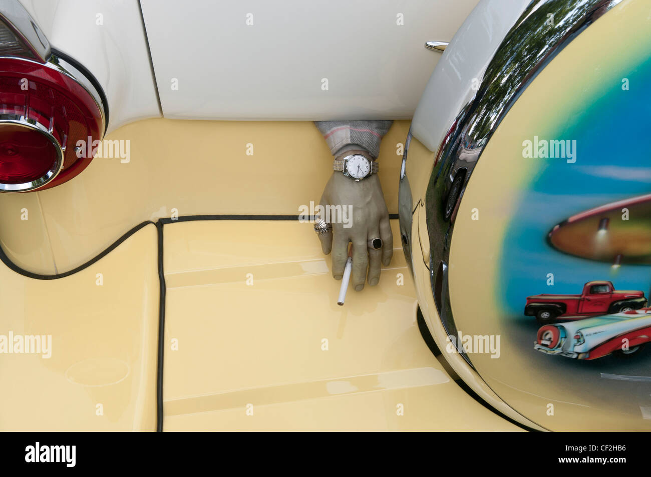 The rear of an American 1950's car with a fake arm popping out from the ...