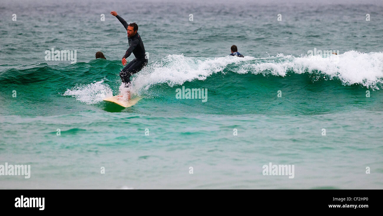A surfer riding the waves at Sennen Stock Photo - Alamy