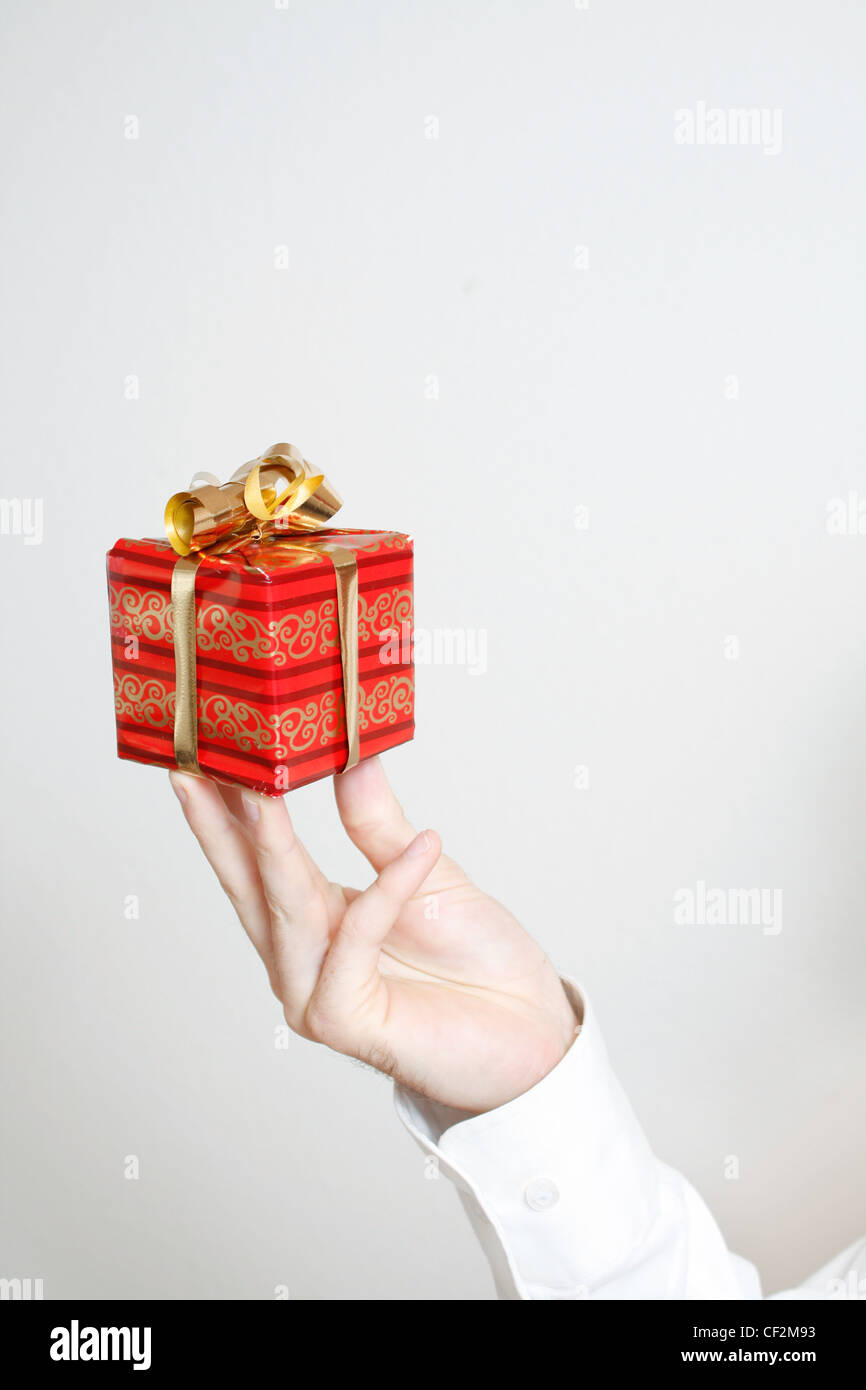 A hand holding a small present Stock Photo - Alamy