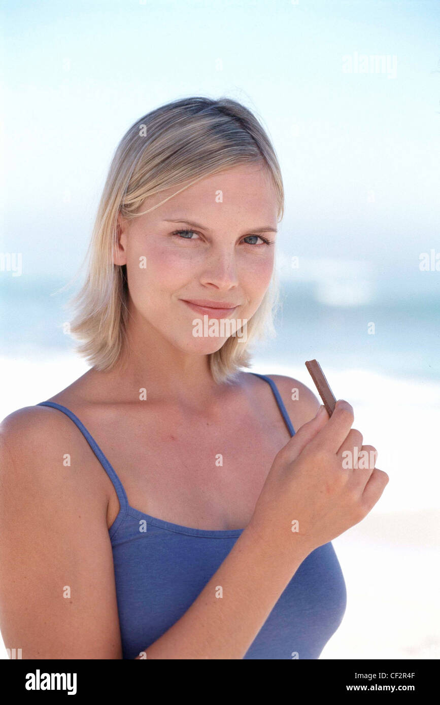 Tanned Female With Chin Length Blonde Hair Wearing Blue Vest Top