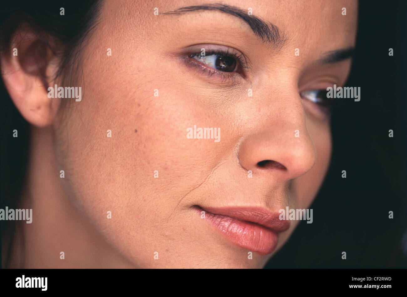 Close up face of female black hair off face wearing subtle make up ...