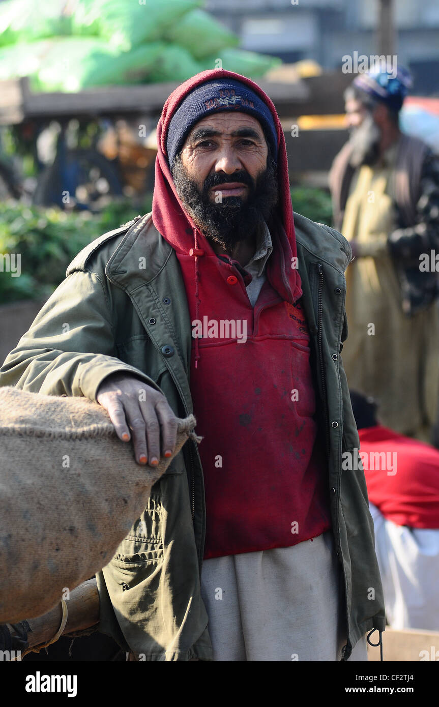 An old man with a beard buying things from the subzi mandi (fruit and ...