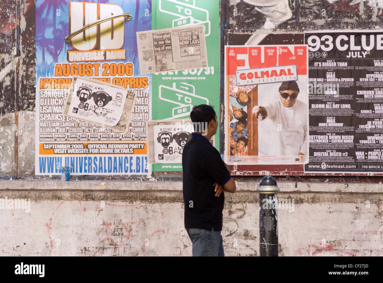 Man looking at posters in Brick Lane. Brick Lane is the heart of the ...