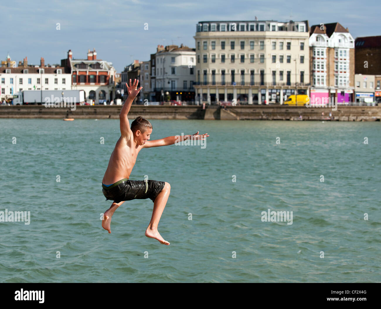 A boy jumping off the harbour arm into the sea at Margate Stock Photo ...