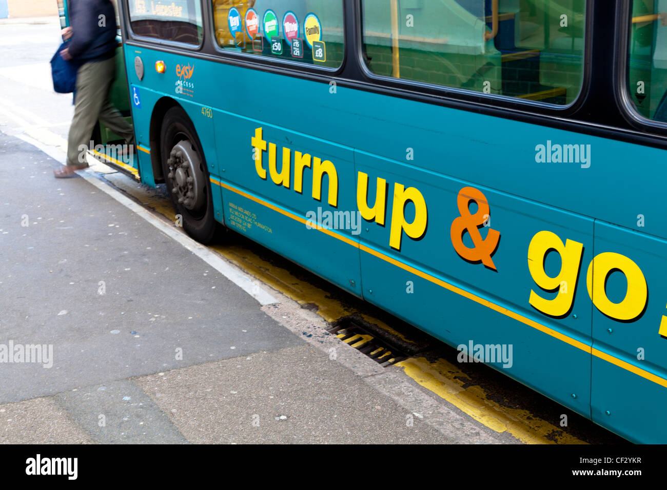 Man steps onto the pavement from the front of a single decker bus Stock ...