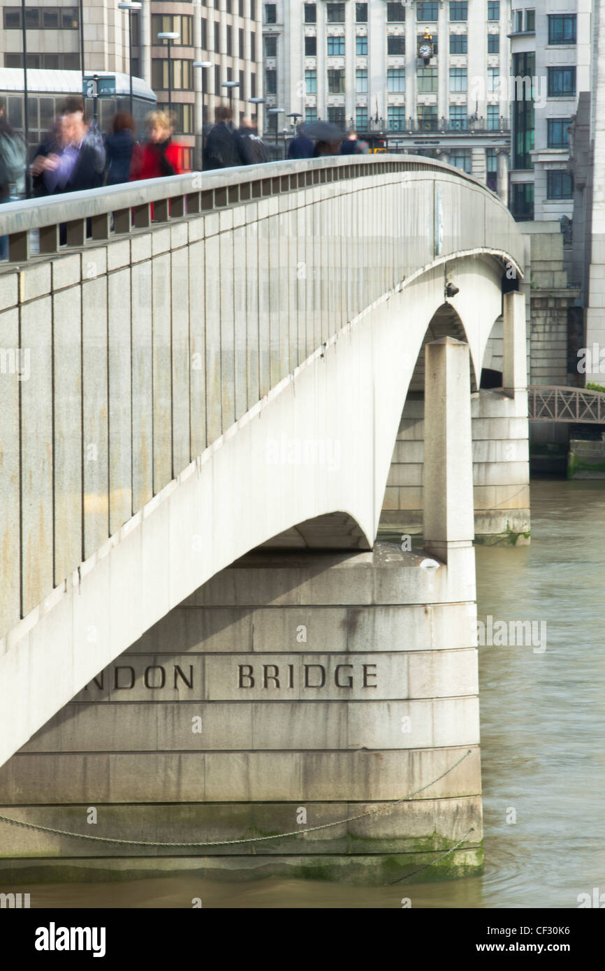 A view of people walking over London Bridge with the river thames ...