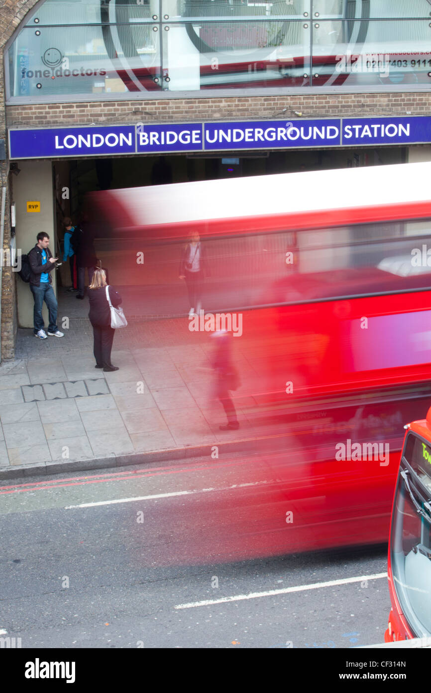 A view of a tradional red London bus as it passes London Bridge ...