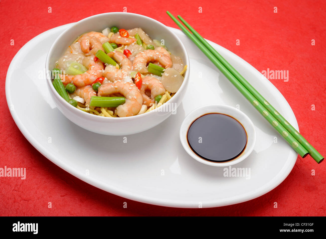 A bowl of stir fried prawns spring onion served egg noodles, and a ...