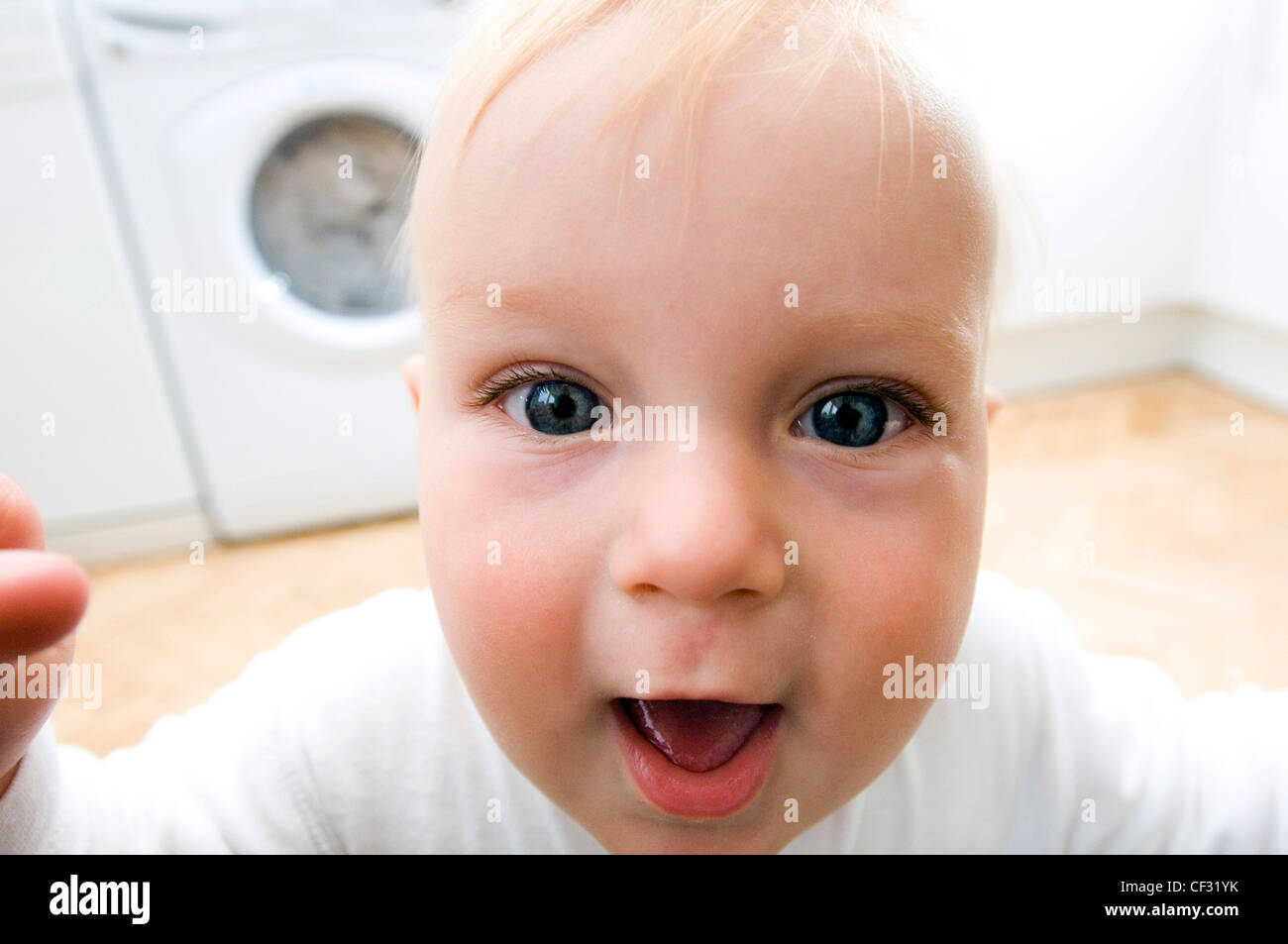 Close up fish eye view of blonde male child aged months wearing a white ...