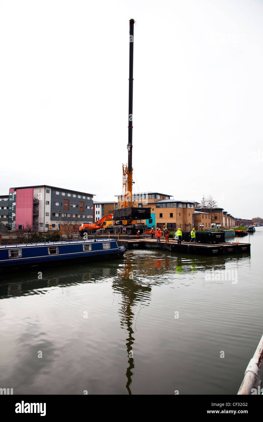 High rise tower crane lifting large floating blocks on river Witham in ...