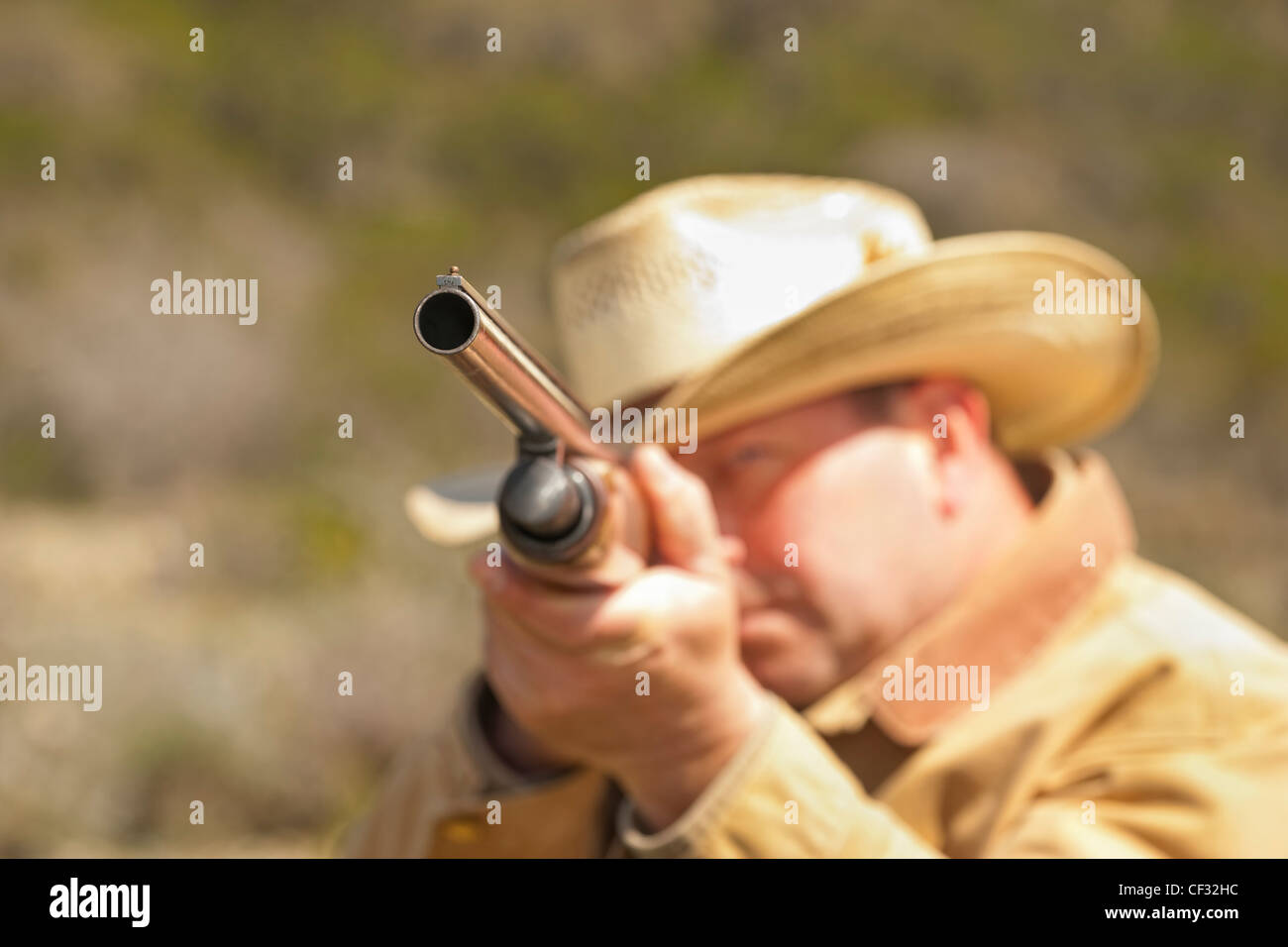 Older man with cowboy hat shooting shotgun Stock Photo - Alamy