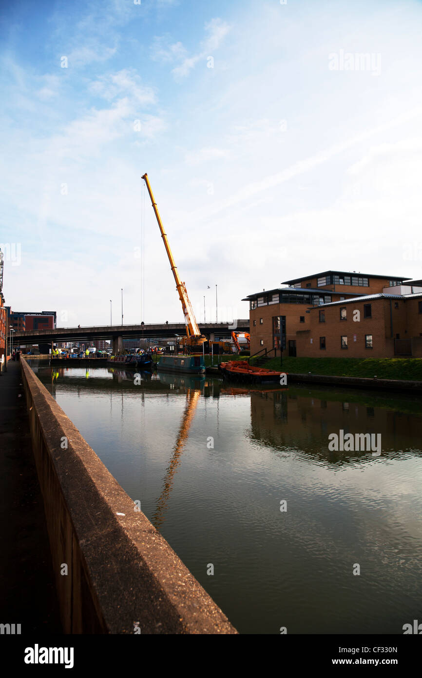 High rise tower crane lifting large floating blocks on river Witham in ...