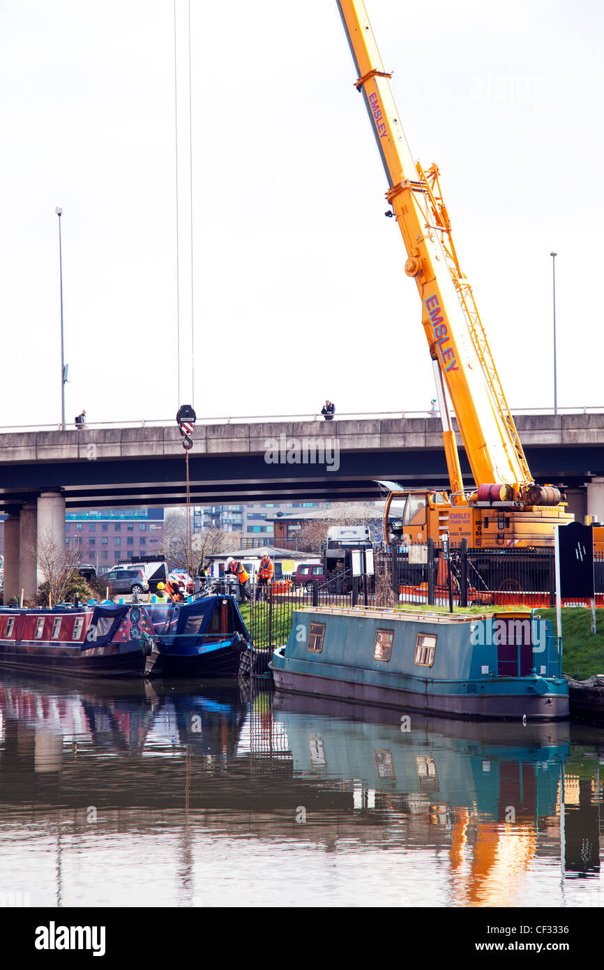 High rise tower crane lifting large floating blocks on river Witham in ...