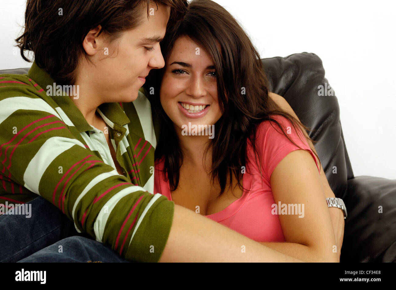 Young Couple Cuddling On Sofa Stock Photos & Young Couple Cuddling On ...