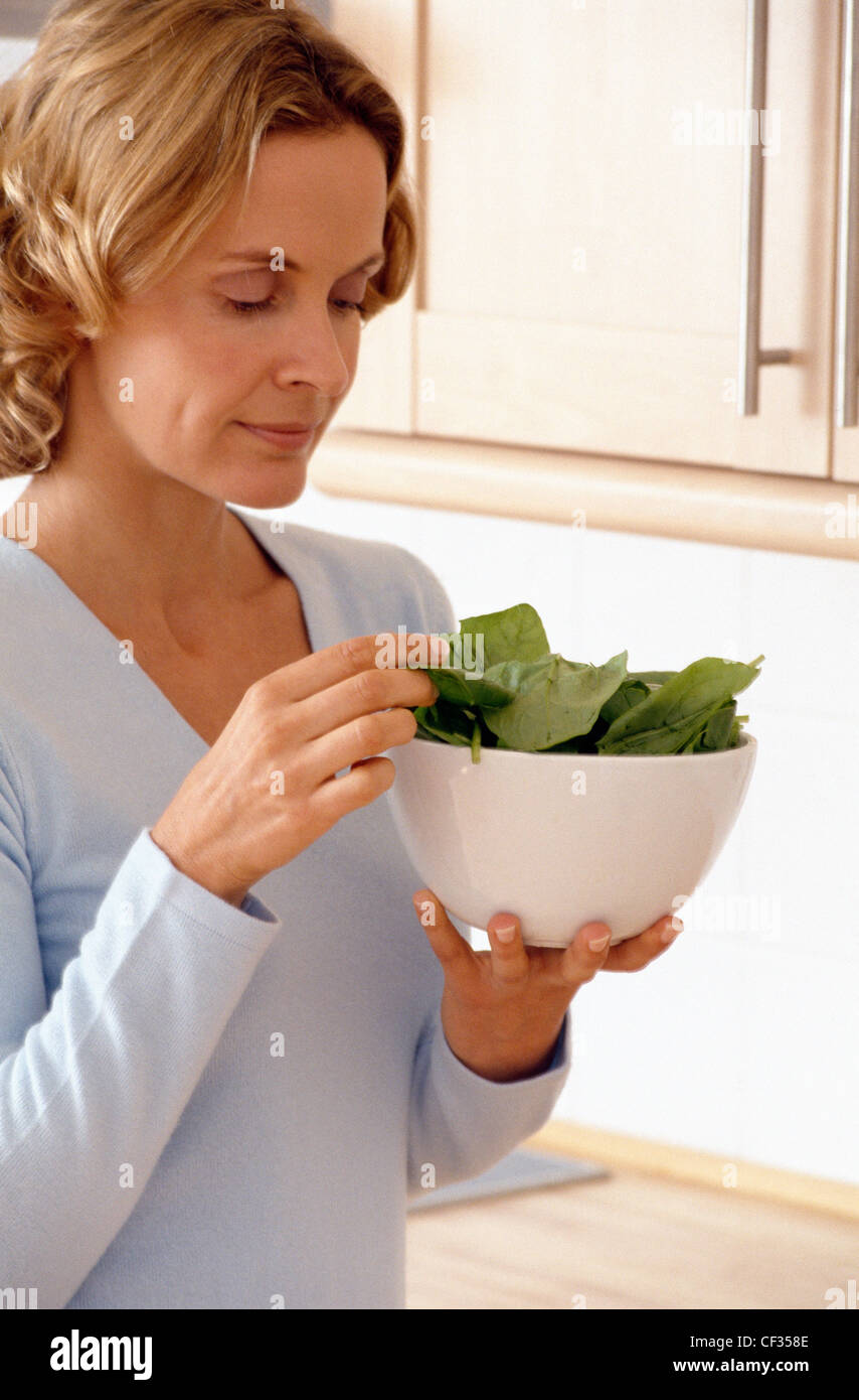 Female short fair hair, wearing a blue v neck top, standing in the ...