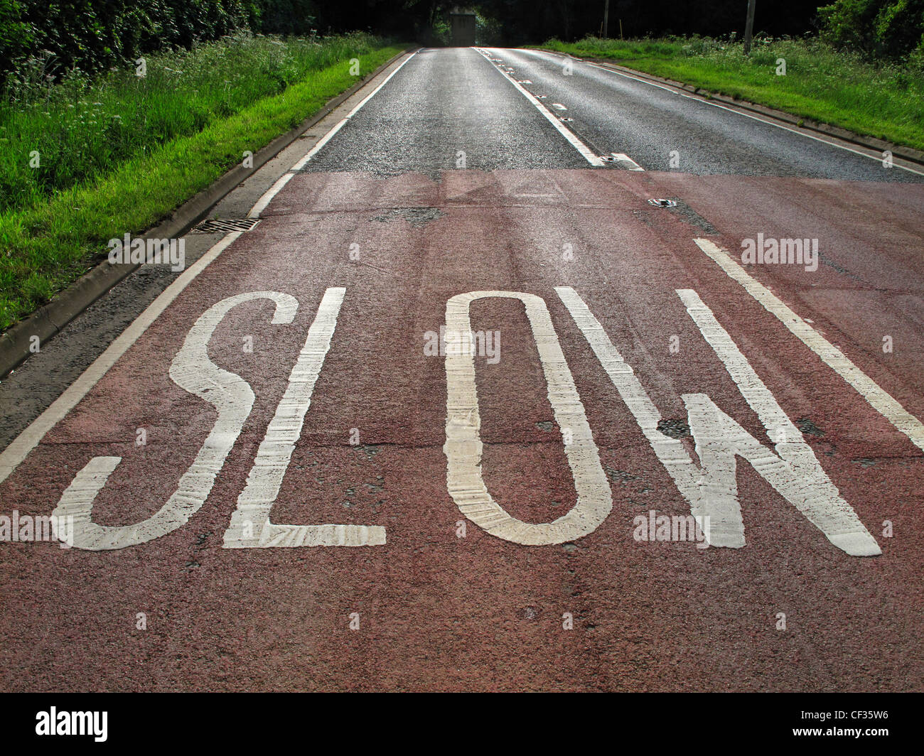 Slow warning sign written on the surface of a rural English road Stock ...