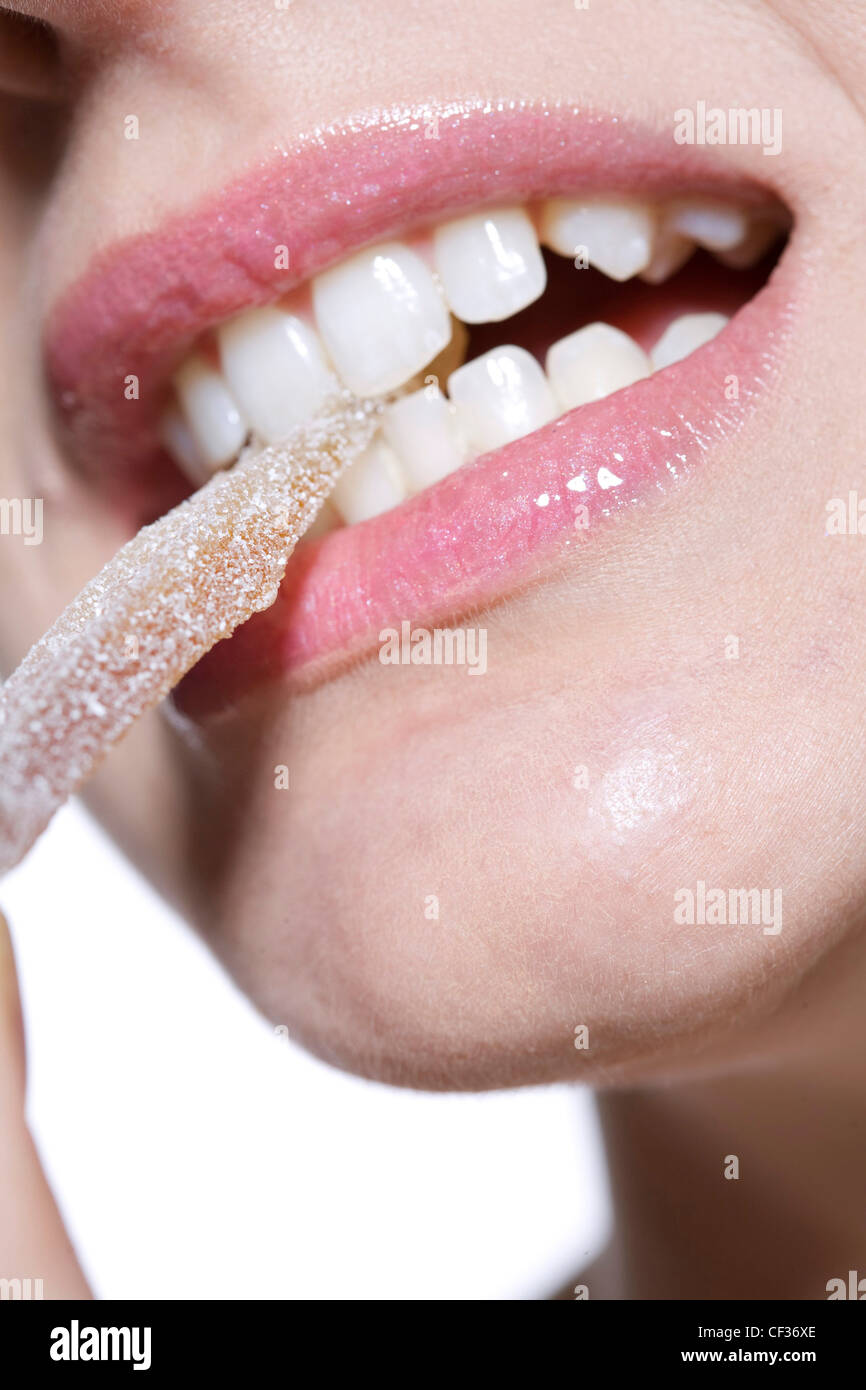 Female wearing pink lipgloss, eating an orange lace Stock Photo - Alamy