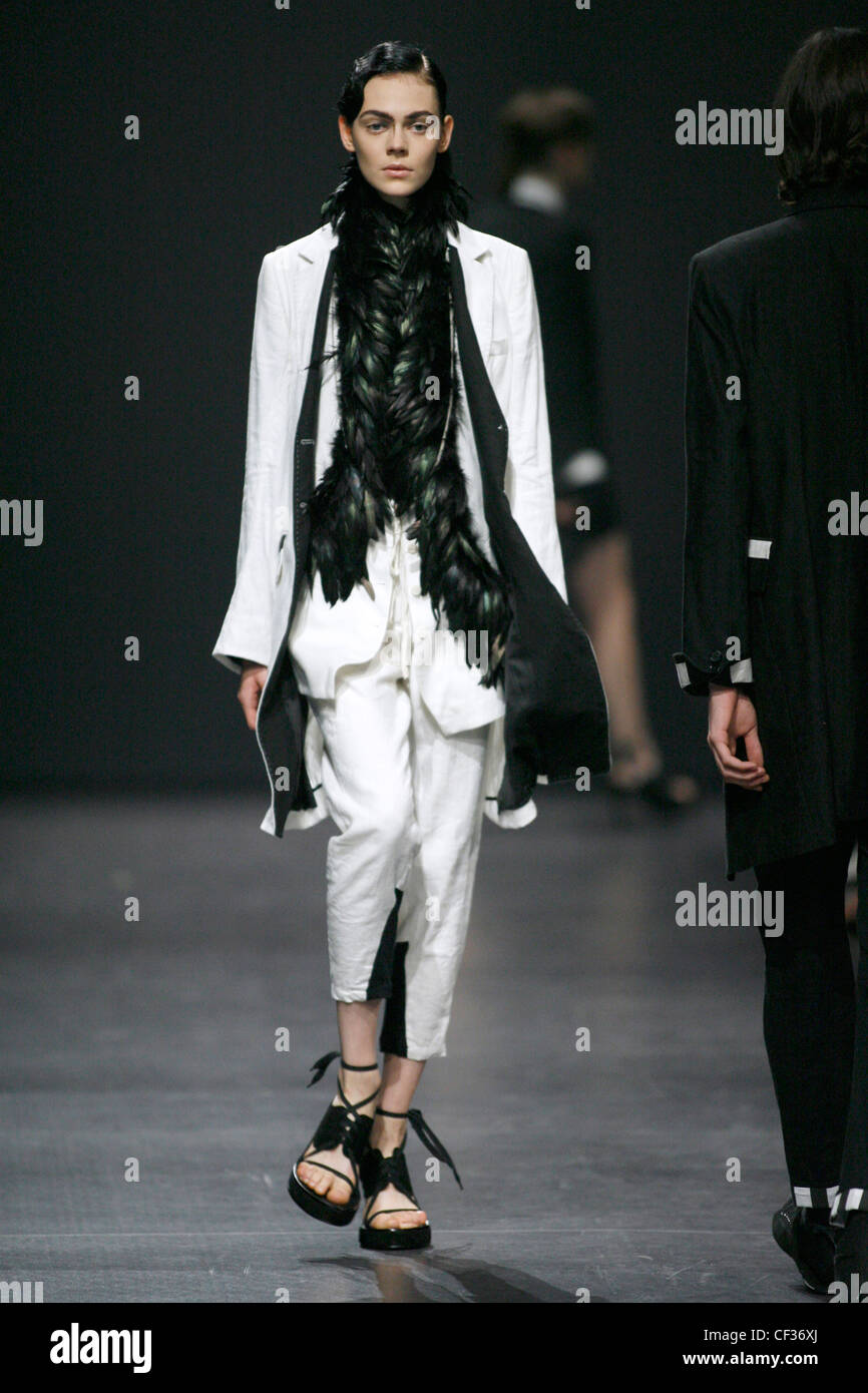 Brunette female model wearing a white cropped trouser suit with black ...
