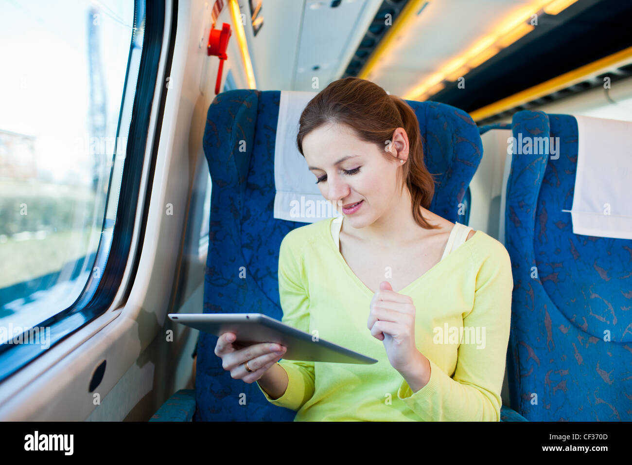 Young woman using her tablet computer while traveling by train Stock ...