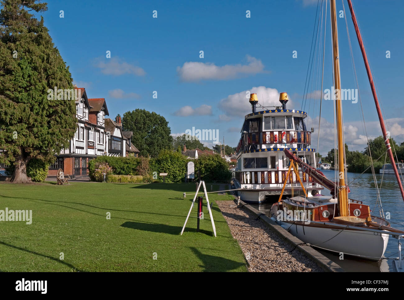 A sailing boat and pleasure boat moored on the River Bure at Horning ...
