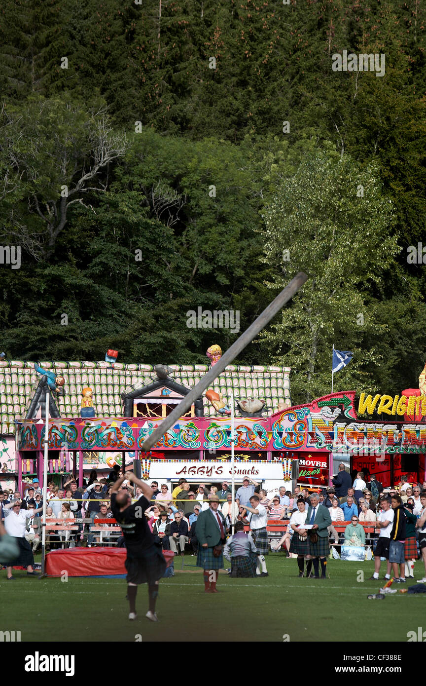 A competitor tossing the caber during the Lonach Highland Games Stock ...