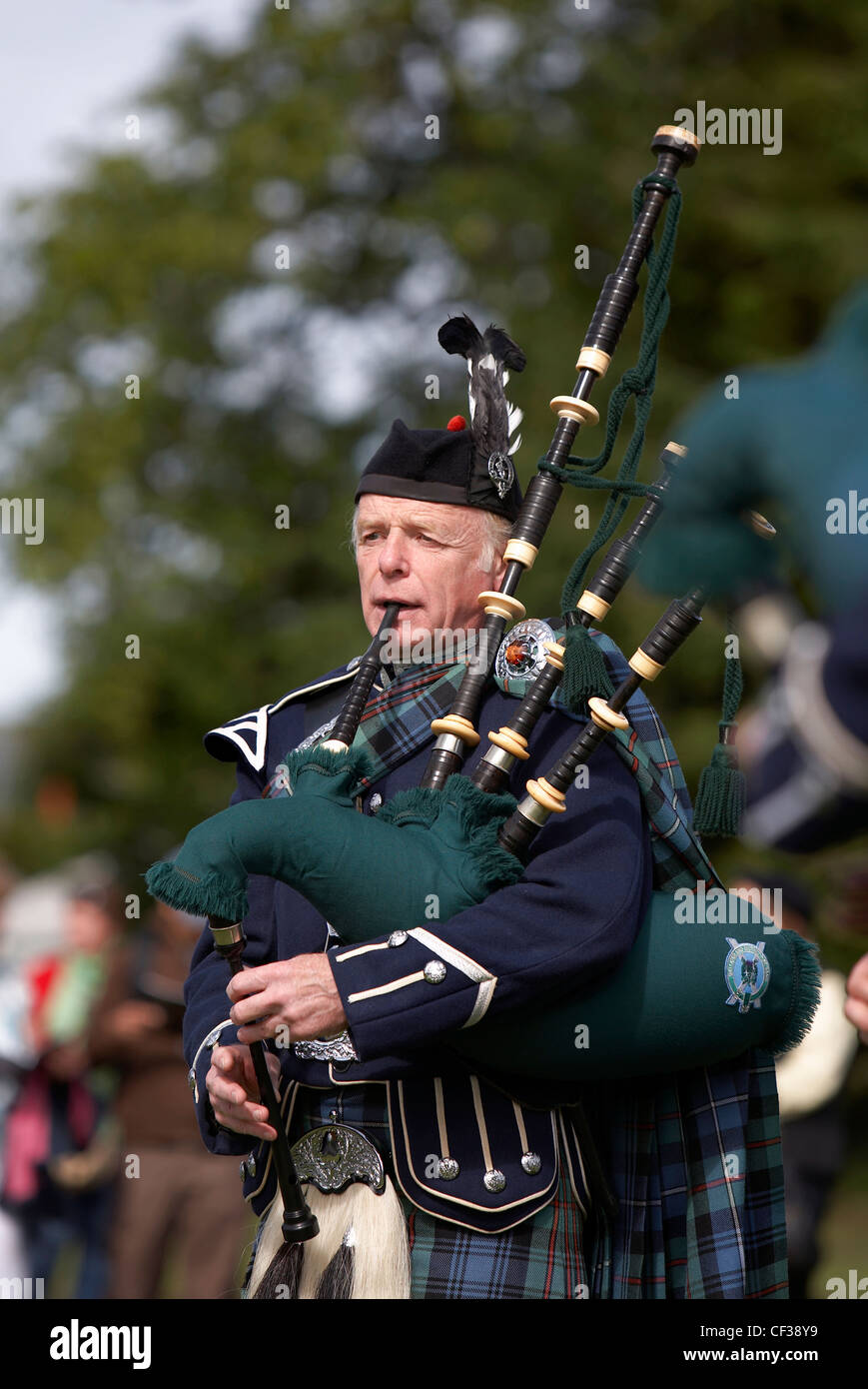 A piper in traditional dress performing at the Lonach Highland Games ...