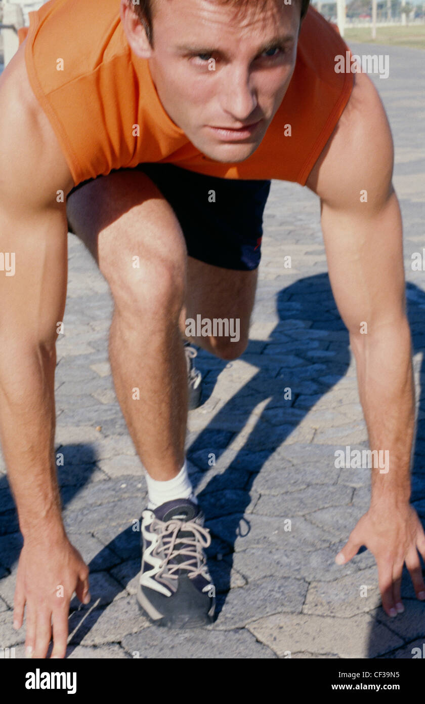 Male crouching down ready to start running Stock Photo - Alamy