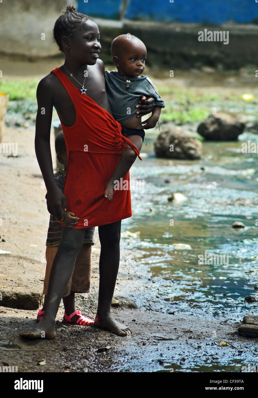 A smiling girl holding a baby in Kenema, Sierra Leone Stock Photo - Alamy