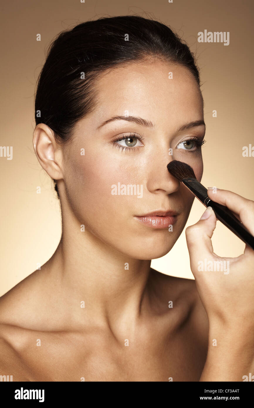 Female applying powder to her nose with a brush Stock Photo - Alamy