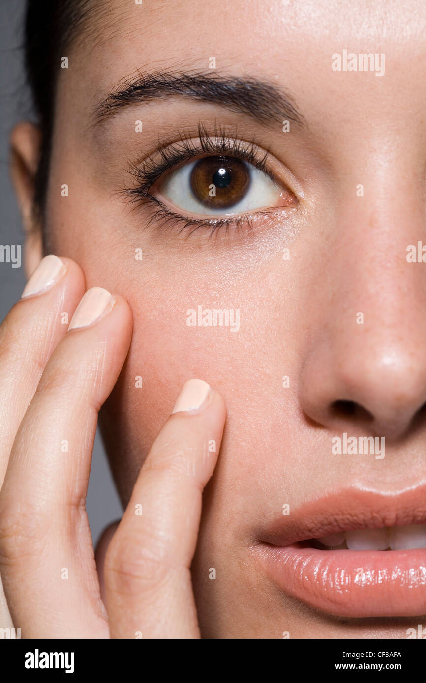 Female wearing natural minimal style make up touching her face with her ...