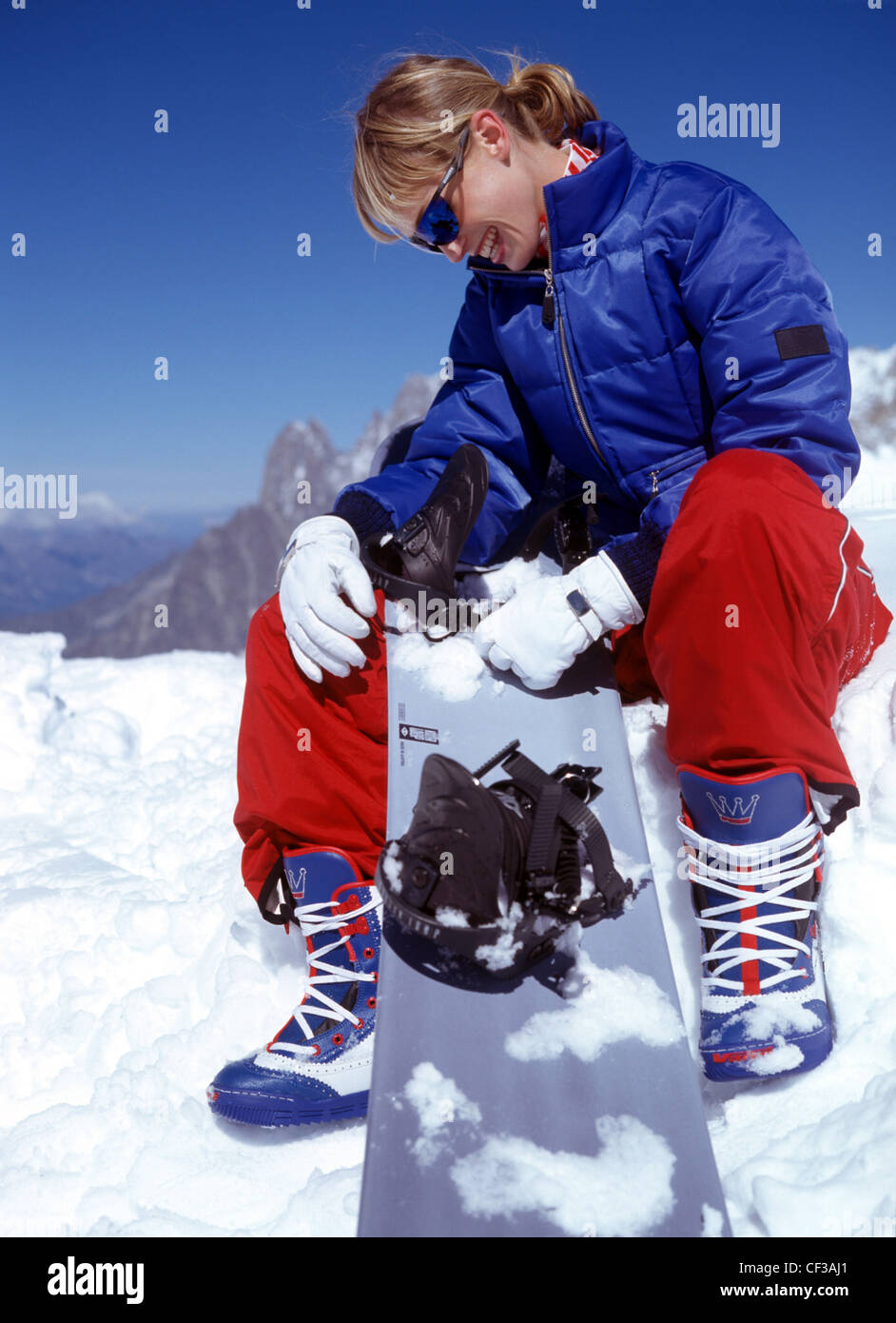 Female sitting down on snowy mountain with her snowboard Stock Photo ...