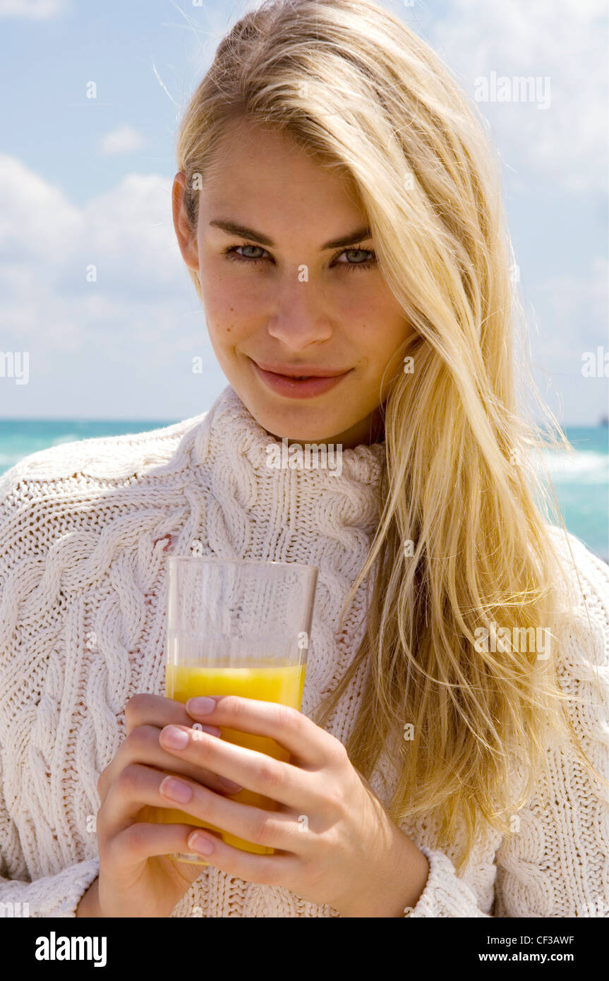 Female Very Long Blonde Hair Wearing Cream Knitted Jumper Holding Glass