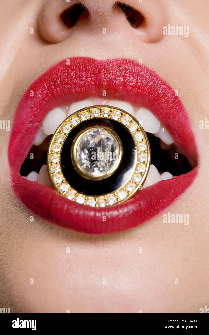 Female with deep pink lipstick, holding a diamond ring between her ...