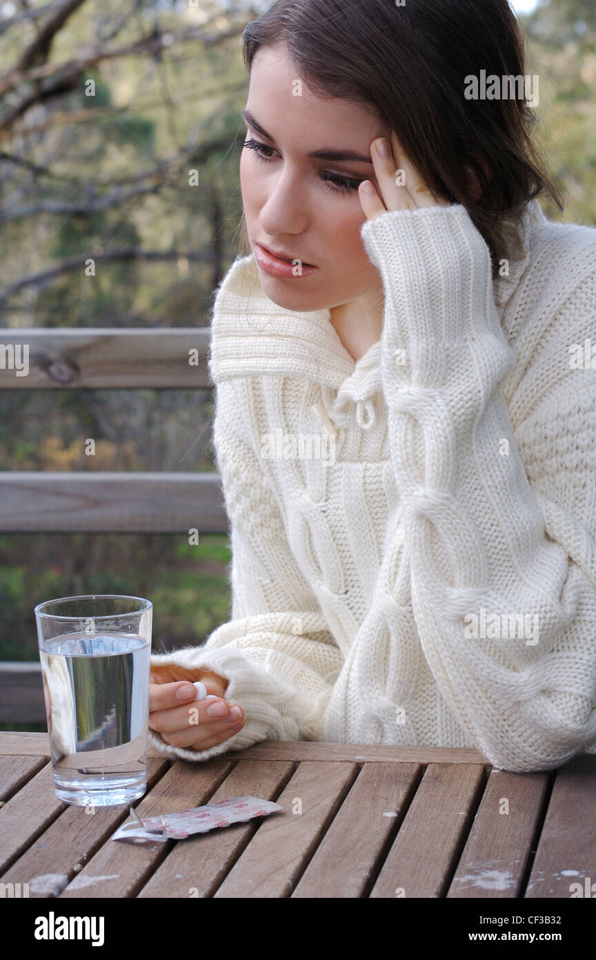Female wearing a cream ribbed knitted jumper, sitting at a wooden table ...