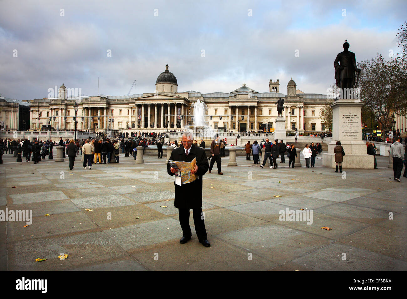 A tourist reads a map in a busy Trafalgar Square Stock Photo - Alamy