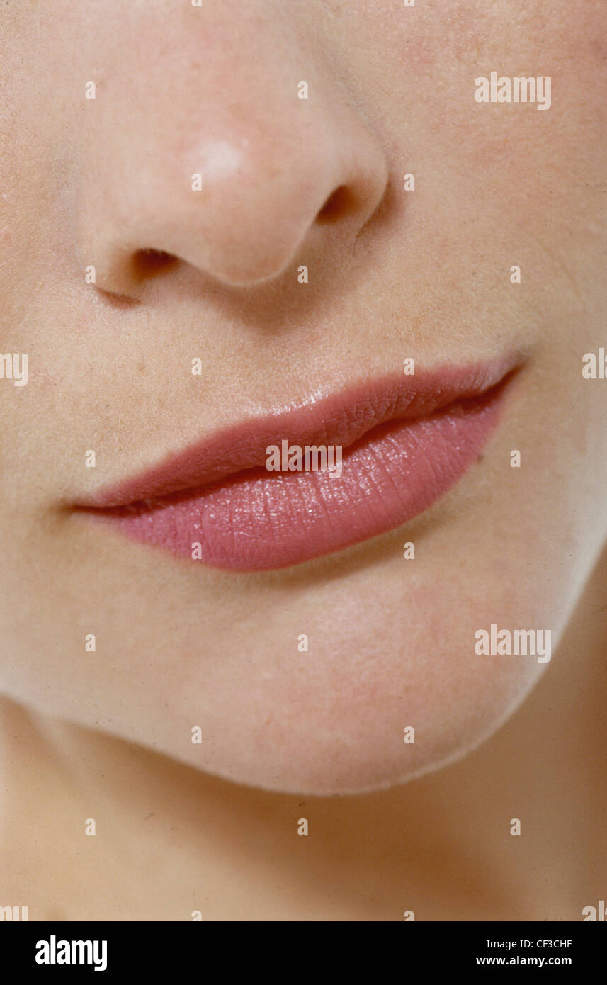 A close up image of cropped female's face, wearing pink lipstick ...