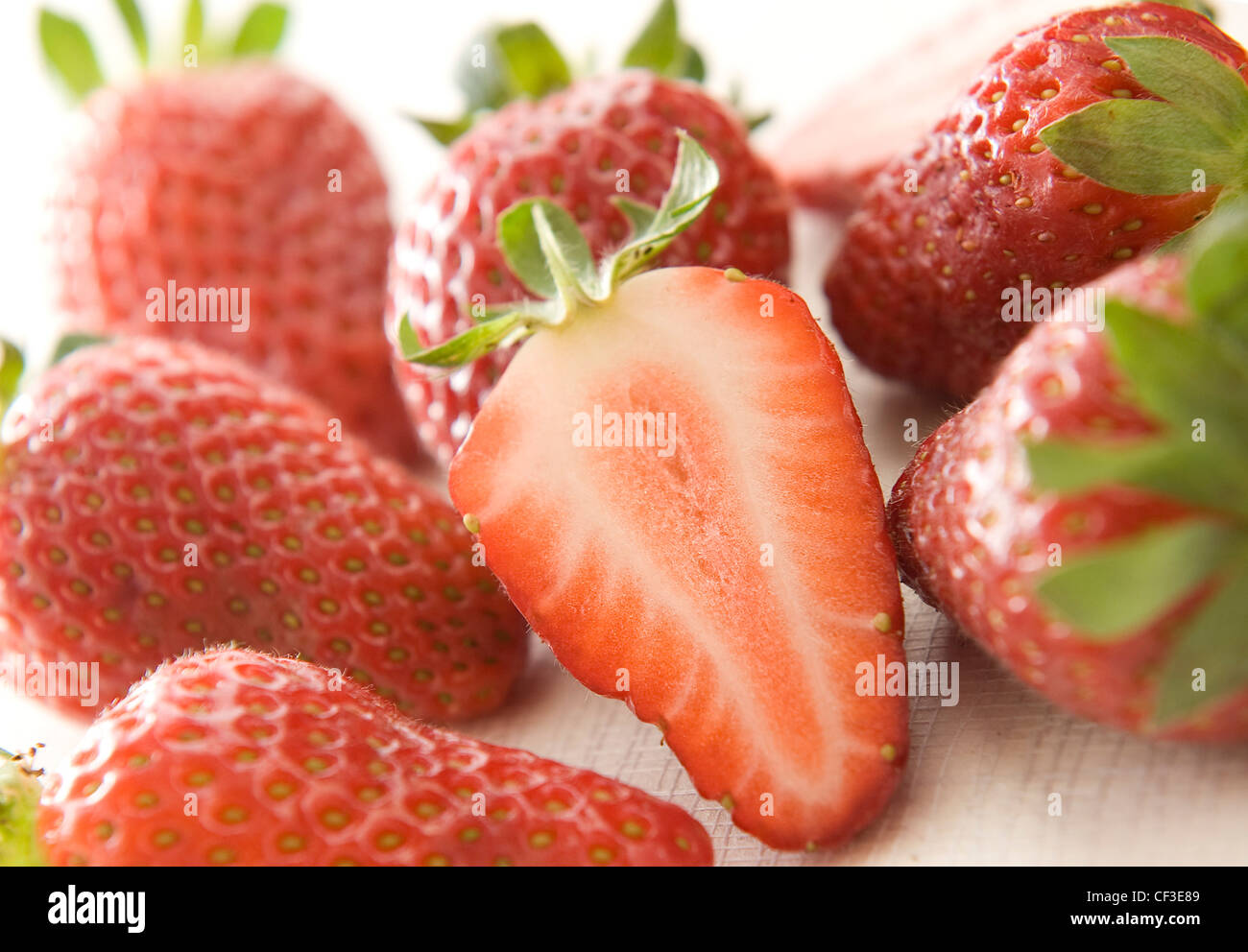 A close up image of fresh strawberries with one strawberry halved Stock ...