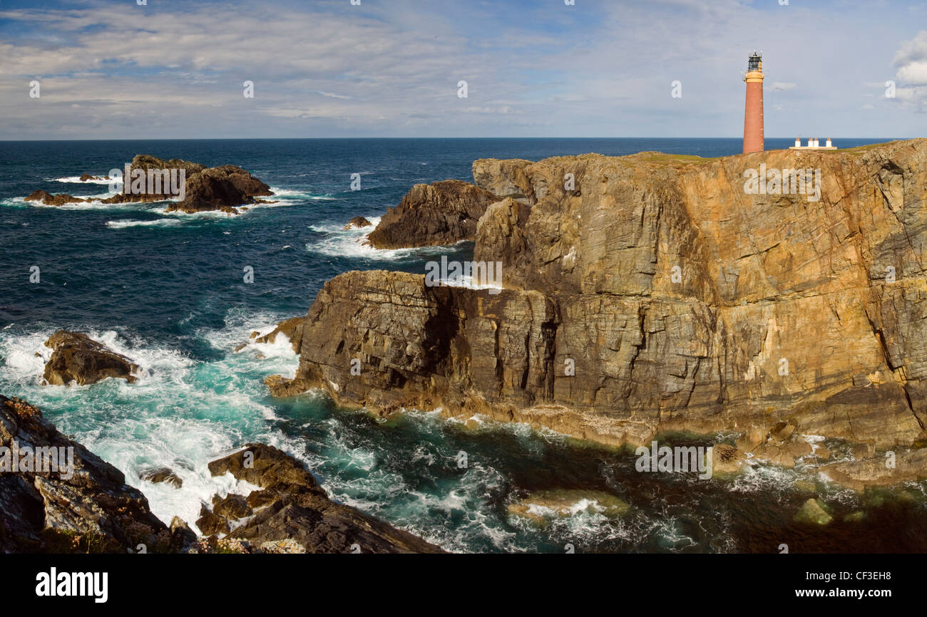 View across a rocky coastline to the lighthouse at the Butt of Lewis ...