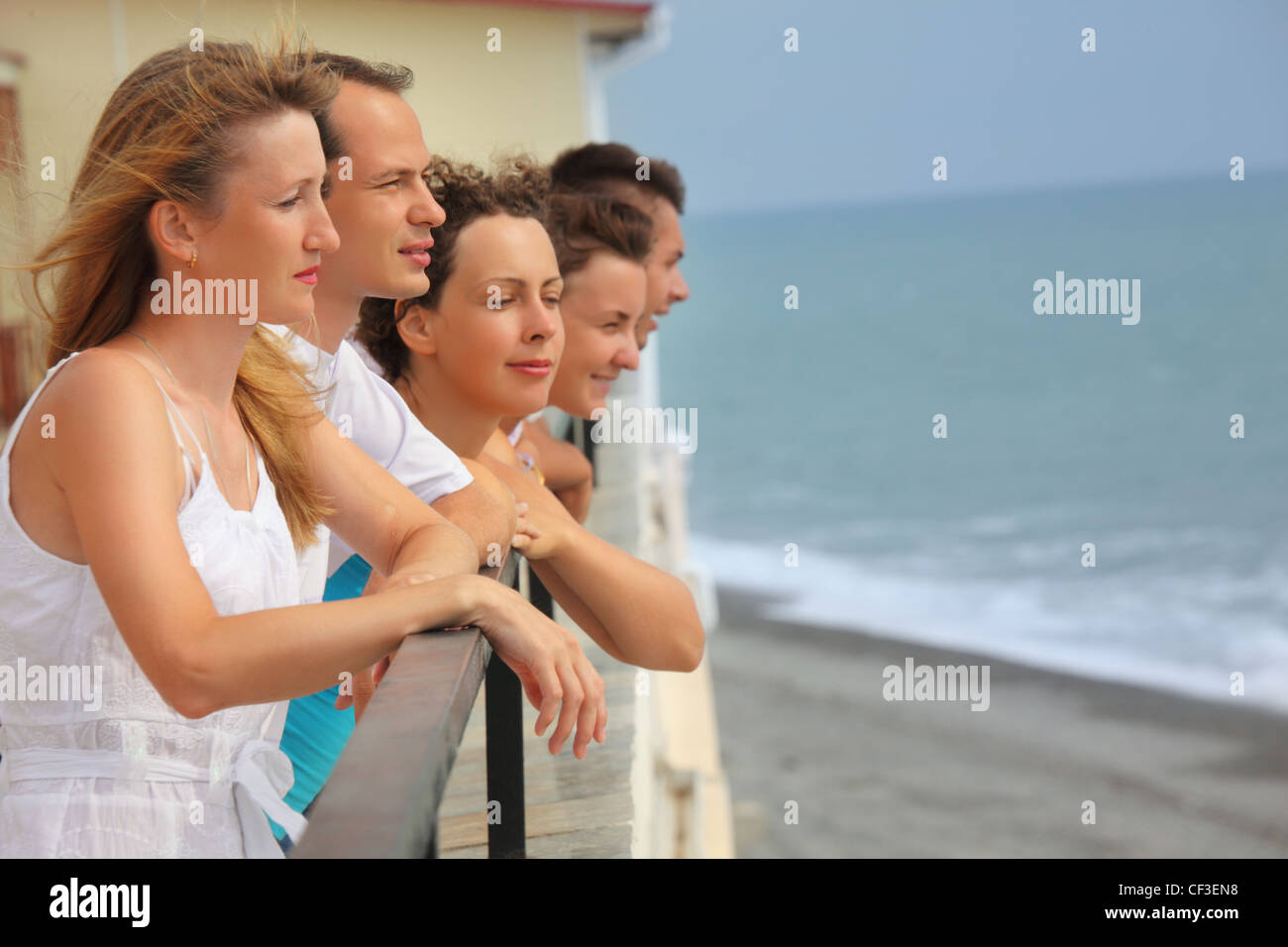 Five smiling friends on balcony Stock Photo - Alamy
