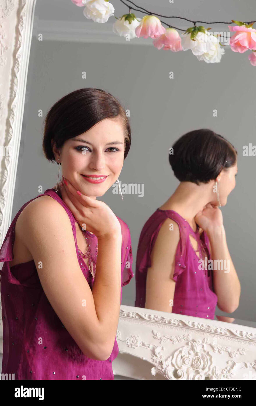 Female short brunette hair, wearing a mauve top cut out chest detail ...