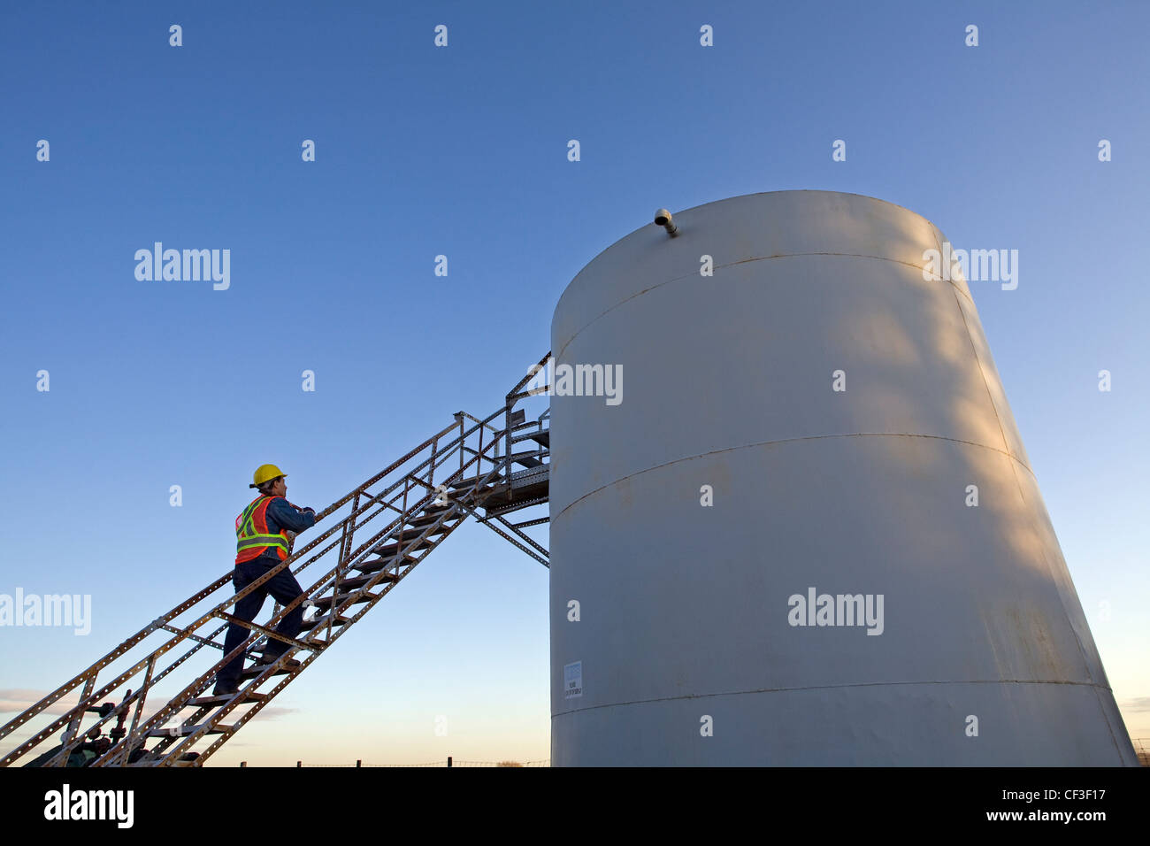 Oil industry worker on storage tank platform talking on phone Stock ...
